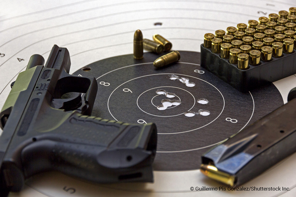 handgun and bullets sitting on target card | National Institute of Justice