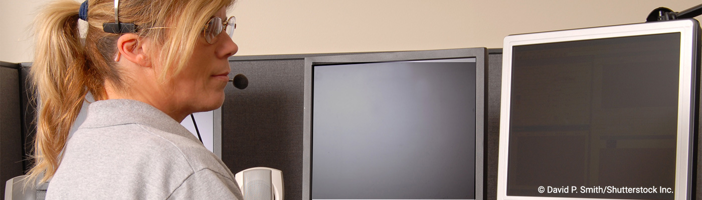 911 dispatcher at a desk hero background | National Institute of Justice