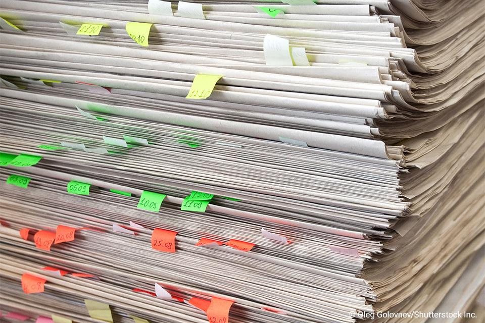 stack of reports with sticky tabs card | National Institute of Justice